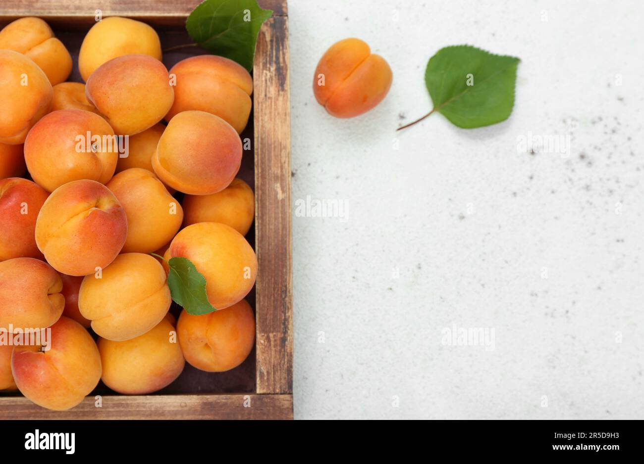 Wooden box with fresh apricots and leaves on white background Stock ...
