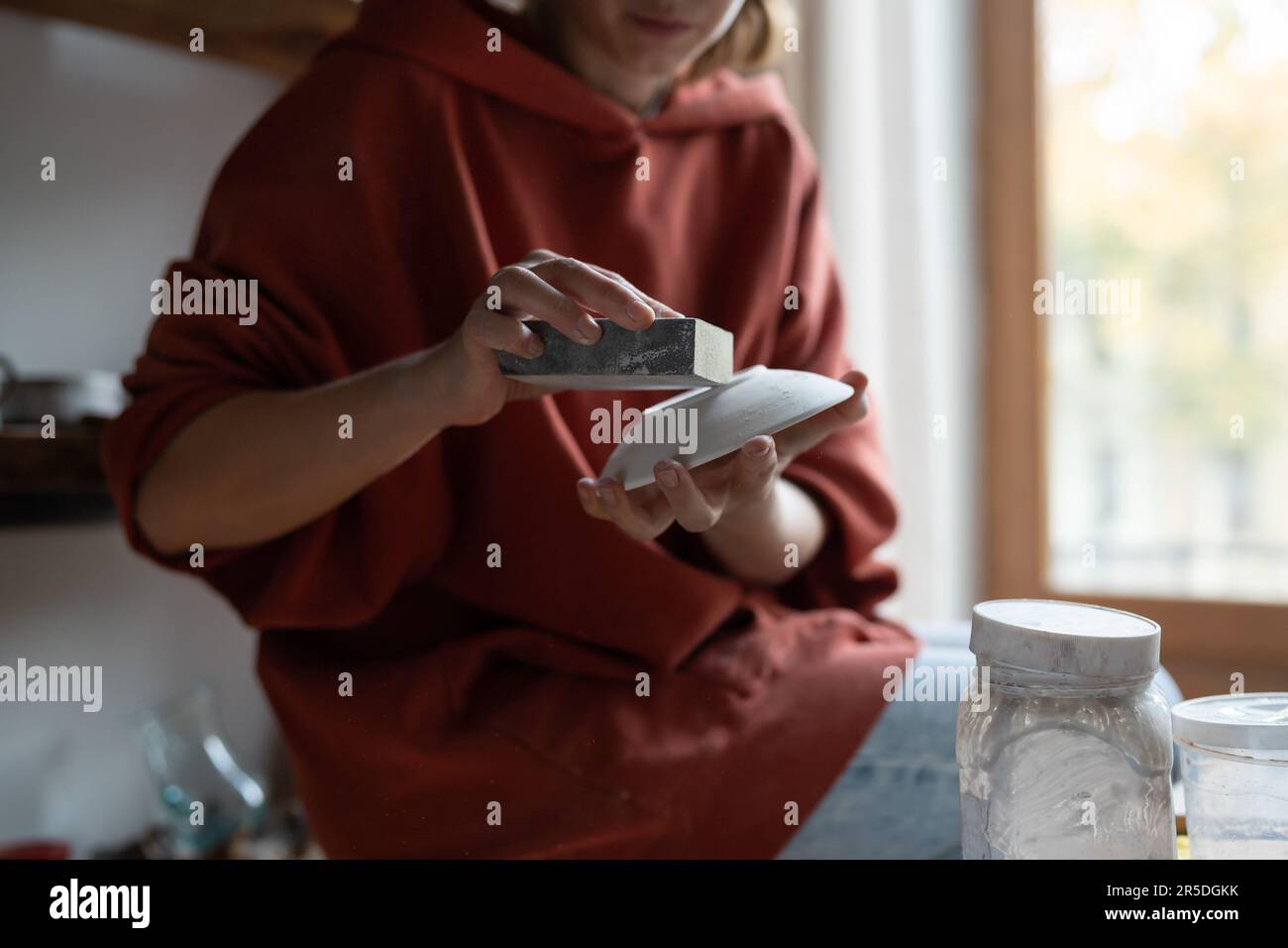 Hands woman owner pottery workshop making handmade dishes from natural ...
