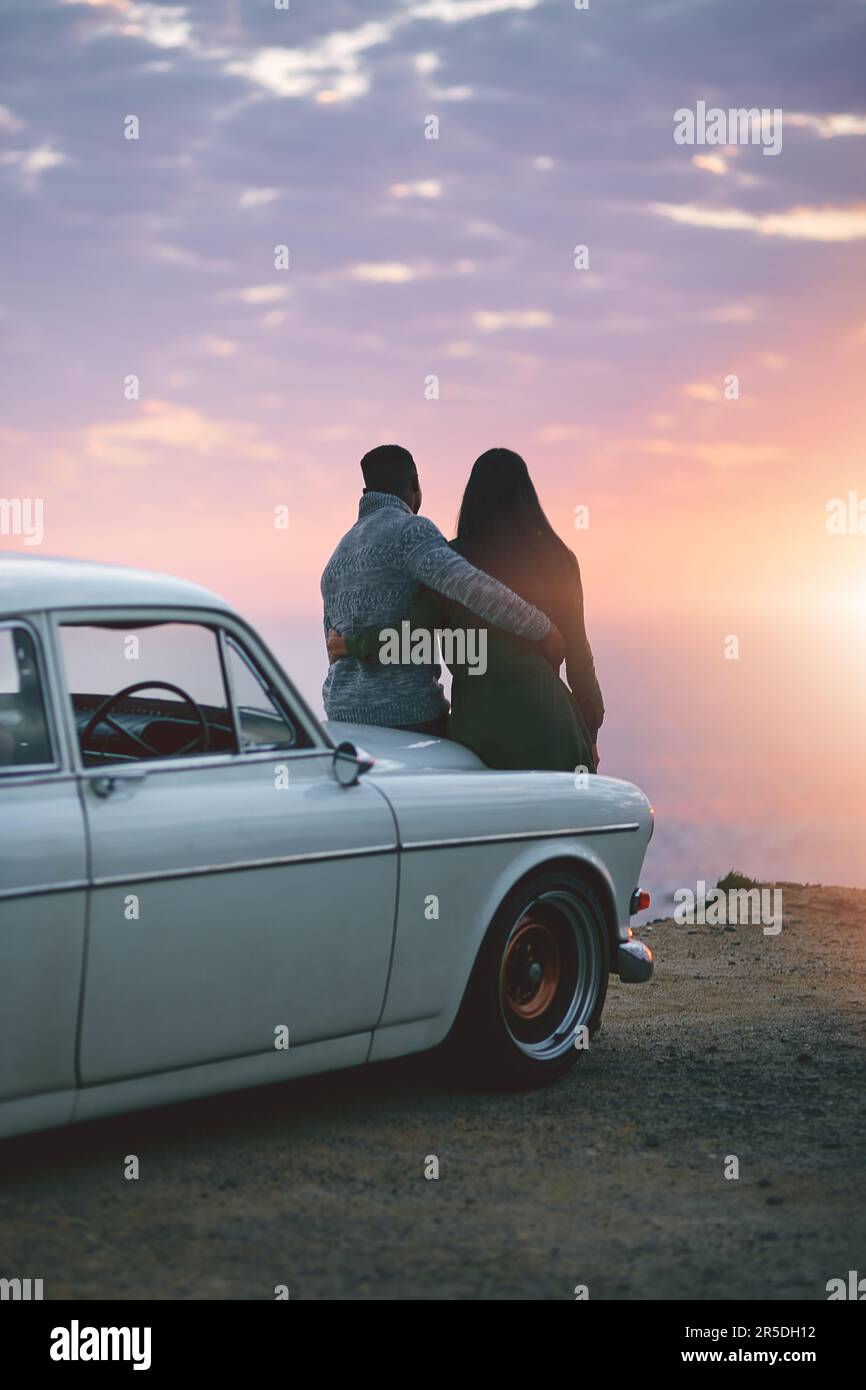 Cherish every sunset. a young couple making a stop at the beach while ...