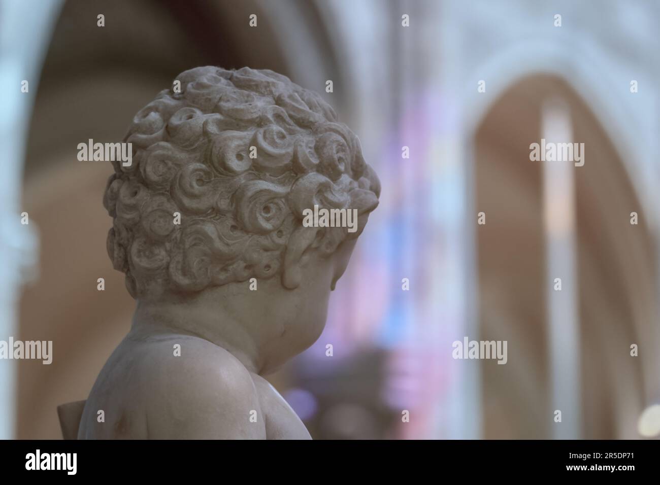 Close up of marble statue back of head of small child, cherub, showing ...