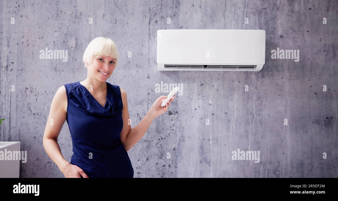 Happy Woman Using Air Conditioner At Home. Conditioning And Heating ...