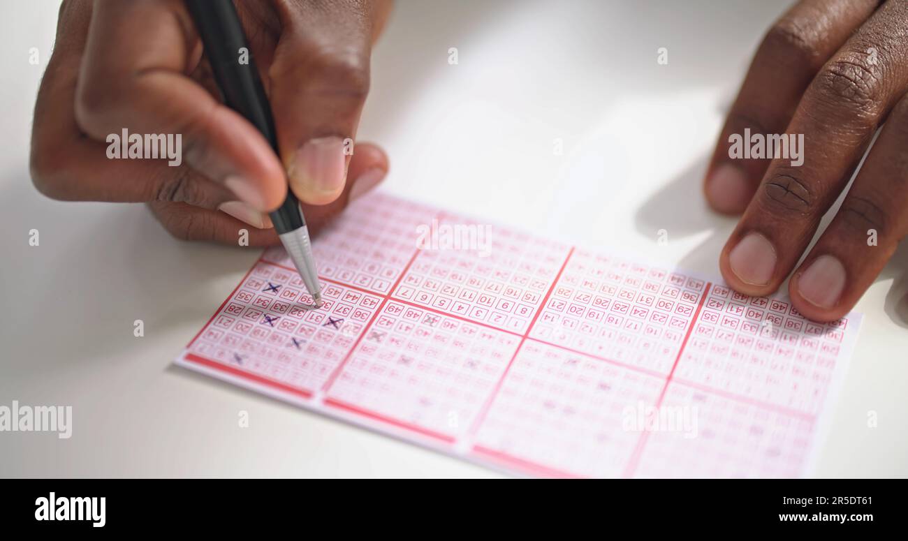 Person's Hand Marking Number On Lottery Ticket With Pen Stock Photo - Alamy