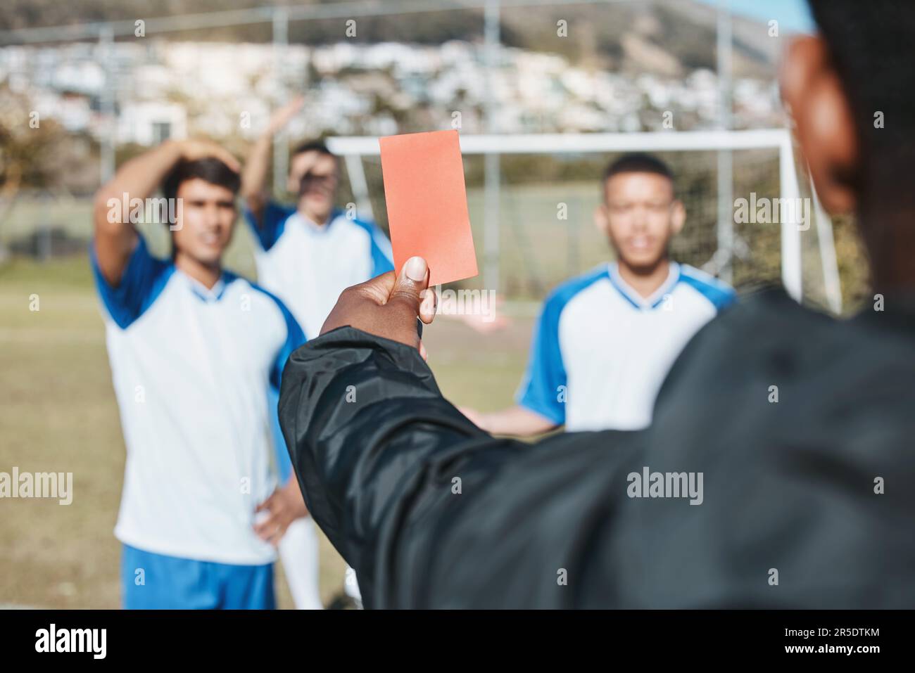 Sports team, red card and soccer referee outdoor on field for game foul ...