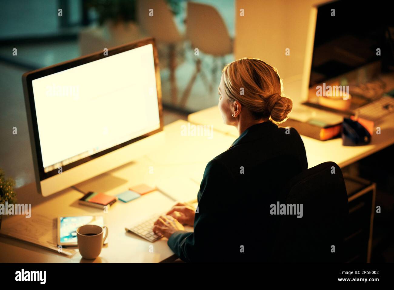 Putting in longer hours to get the work done. a mature businesswoman ...