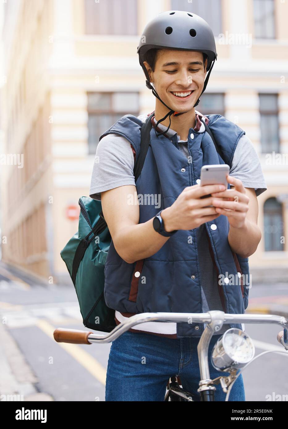 Man, delivery bicycle and smile with phone, order or ecommerce app for food, product and ...