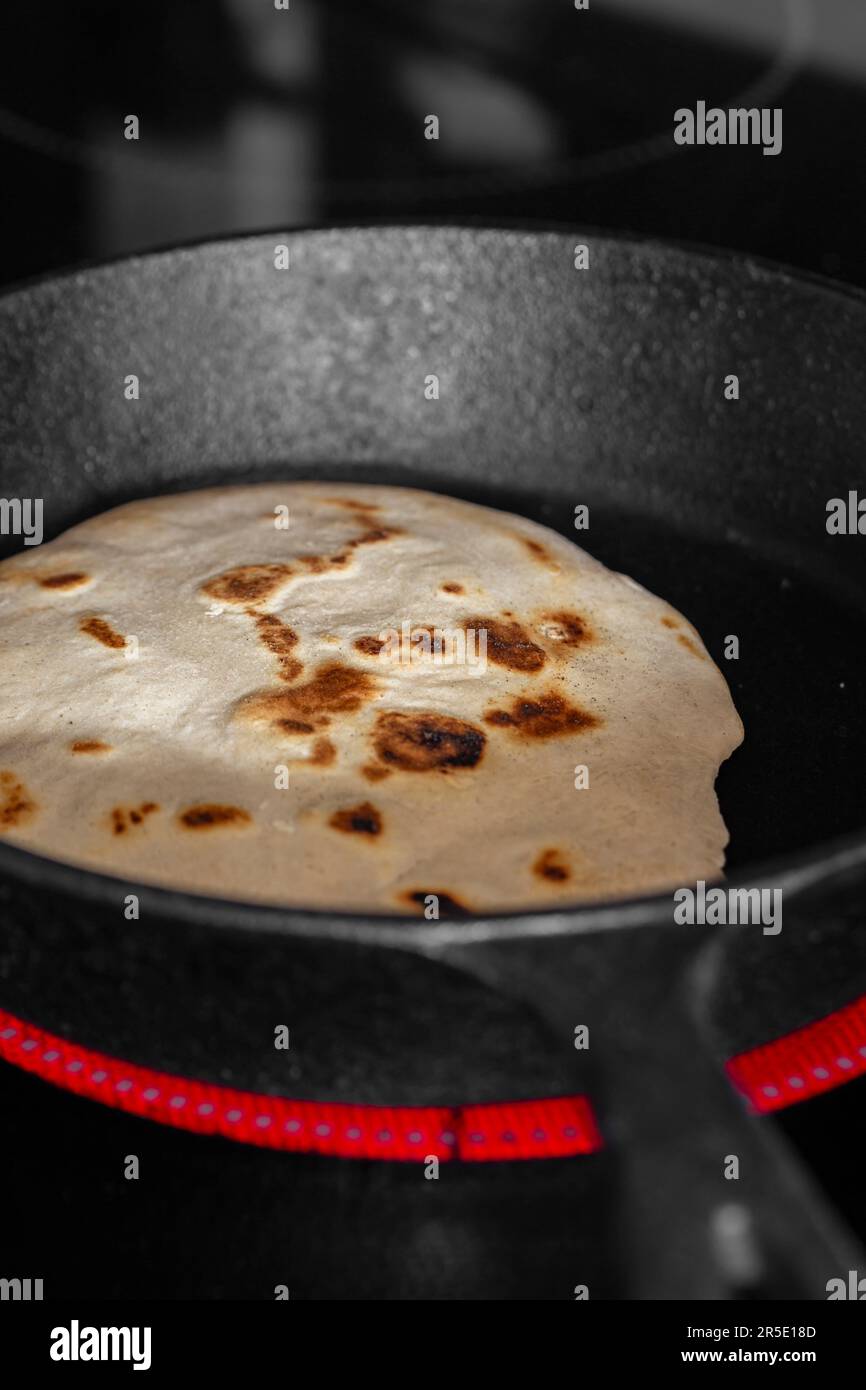 Cooking flatbread in a cast iron frying pan with olive oil. Cooked on ...