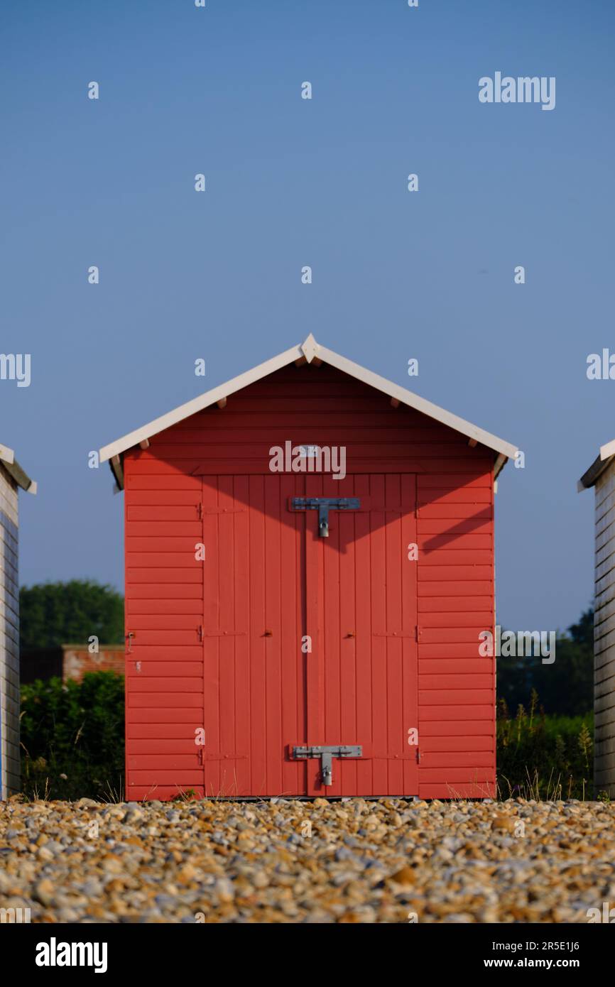Bright red beach hut in Eastbourne beneath a clear blue sky in the ...