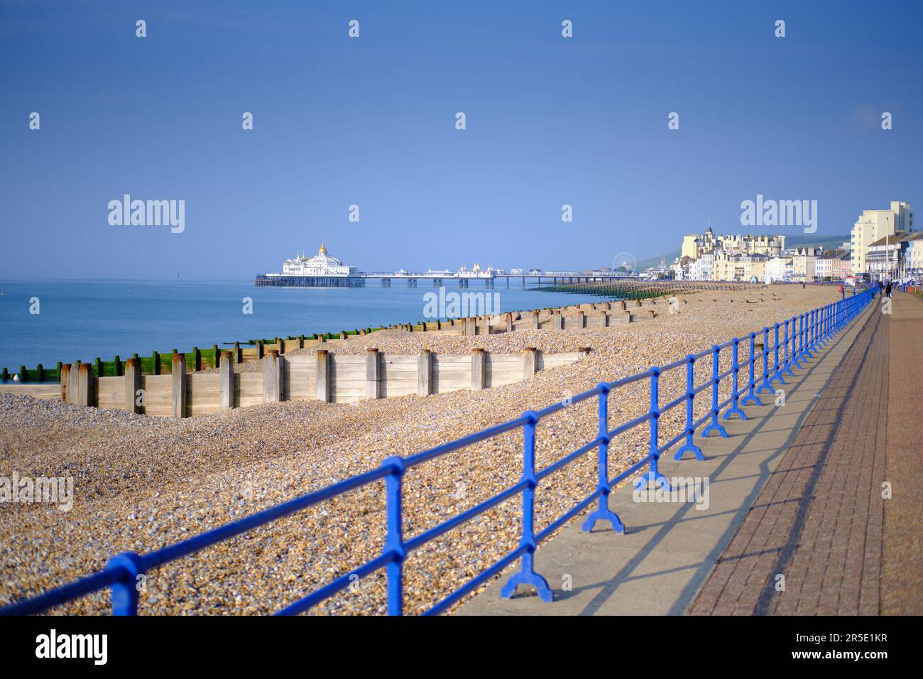 Blue railings on Eastbourne promenade in the summer with clear sky ...