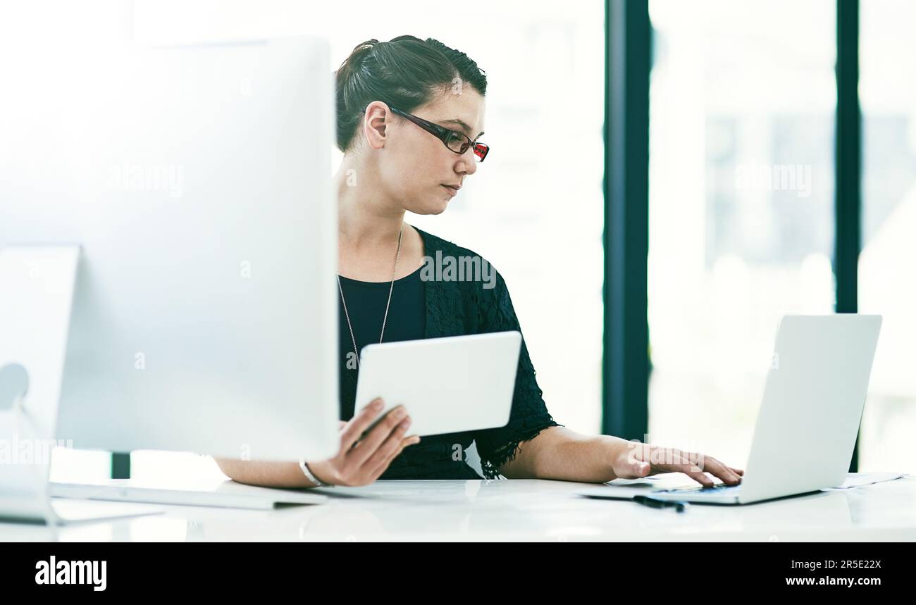 Managing her business processes on multiple devices. a young ...