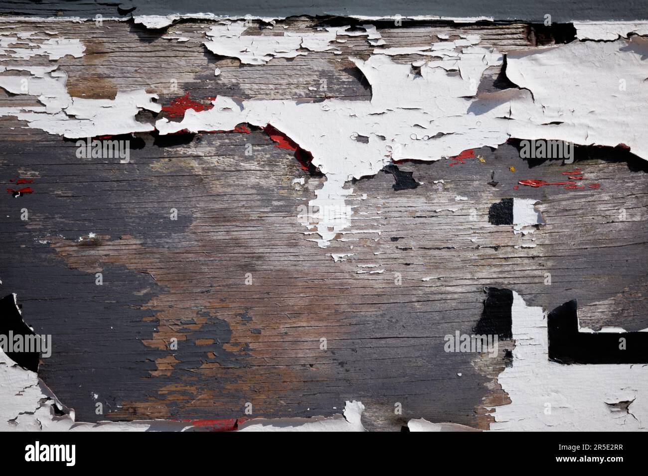 Close up of white weathered paint peeling off the hull of a fishing ...