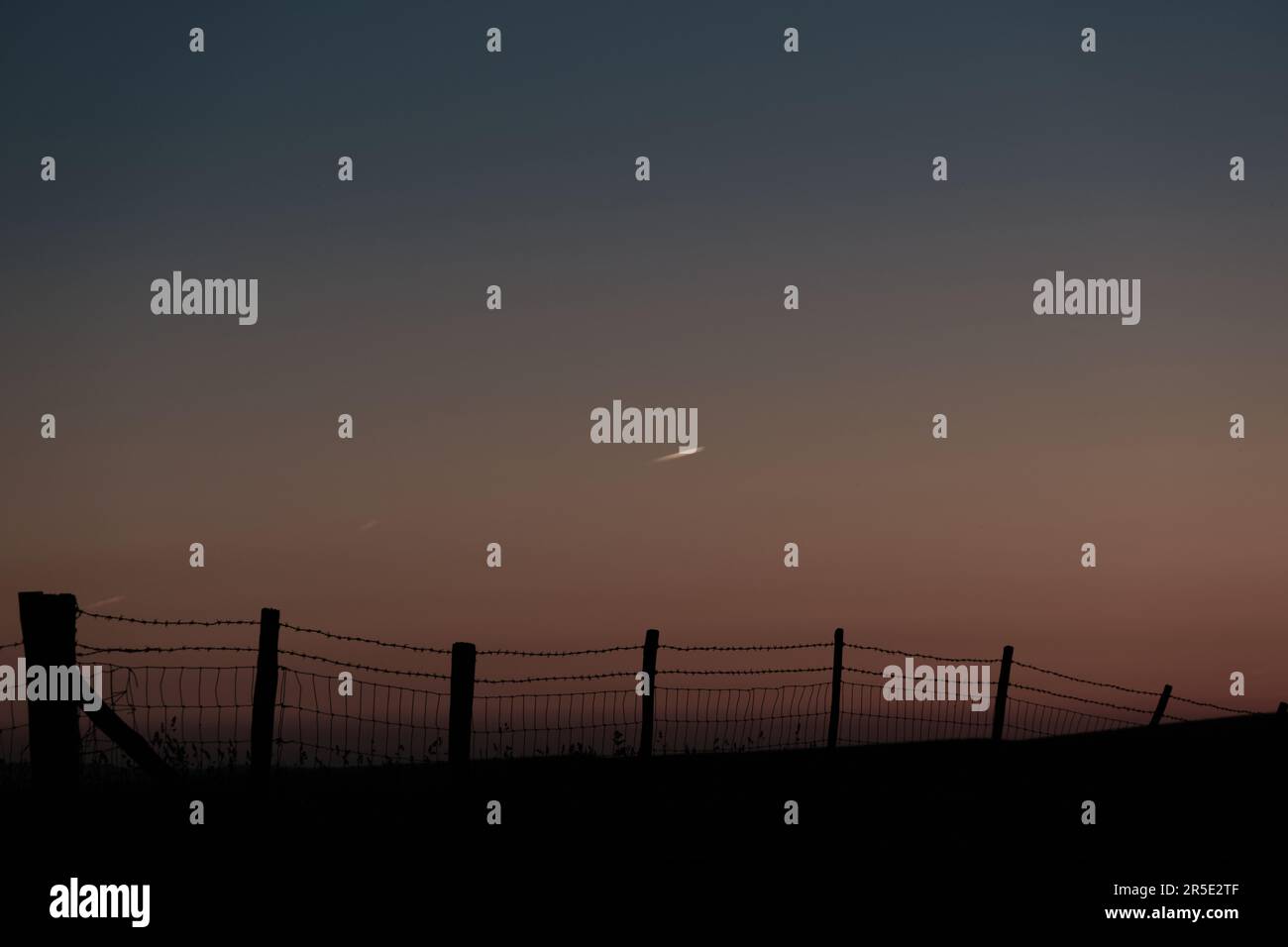 Airplanes fly into the distance at sunset creating vapour trails. A ...