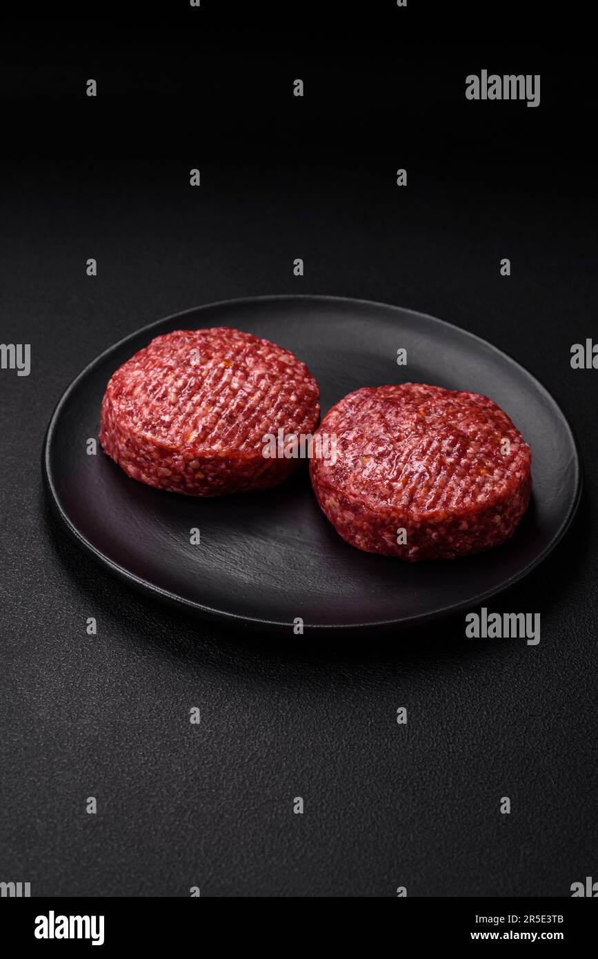 Fresh raw ground beef burger patty with salt and spices on textured ...