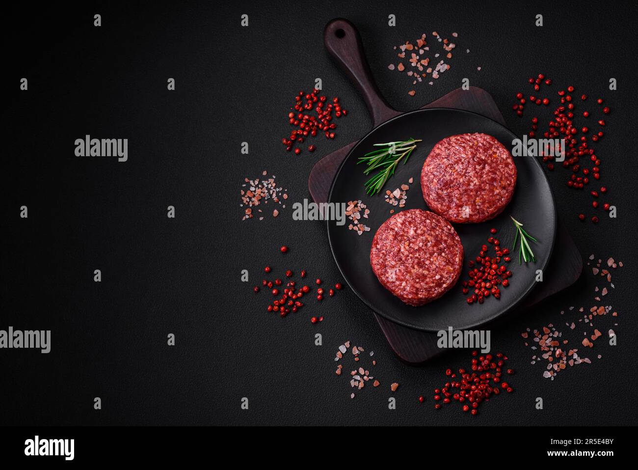 Fresh raw ground beef burger patty with salt and spices on textured ...