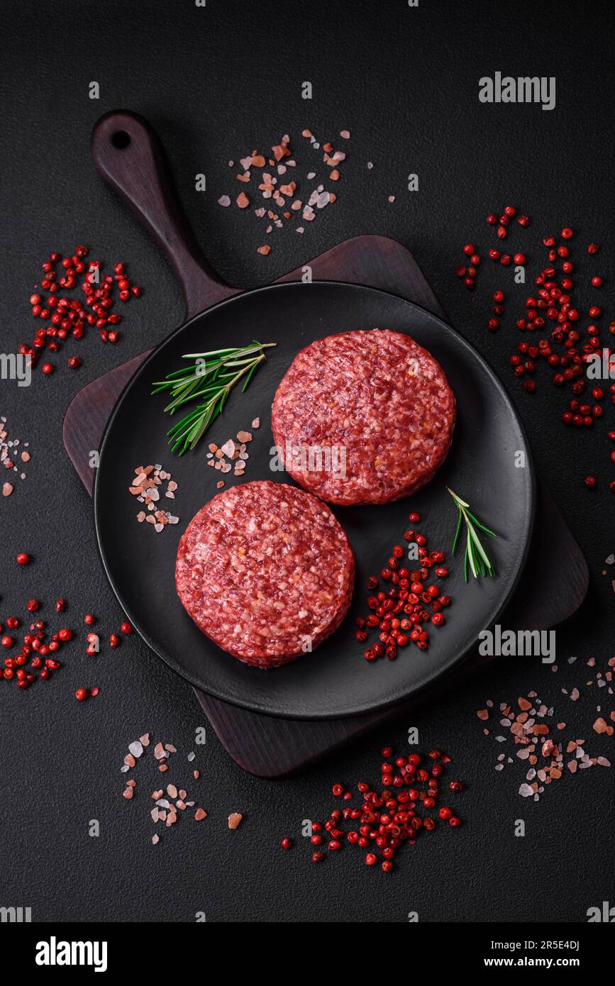Fresh raw ground beef burger patty with salt and spices on textured ...