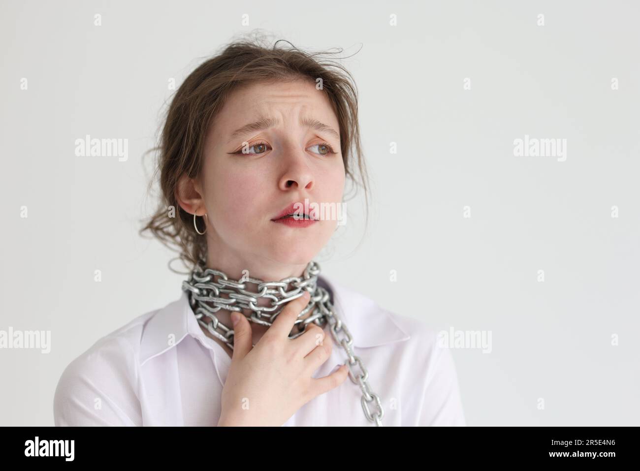 Young female holds on to chained neck feeling pain in throat Stock ...