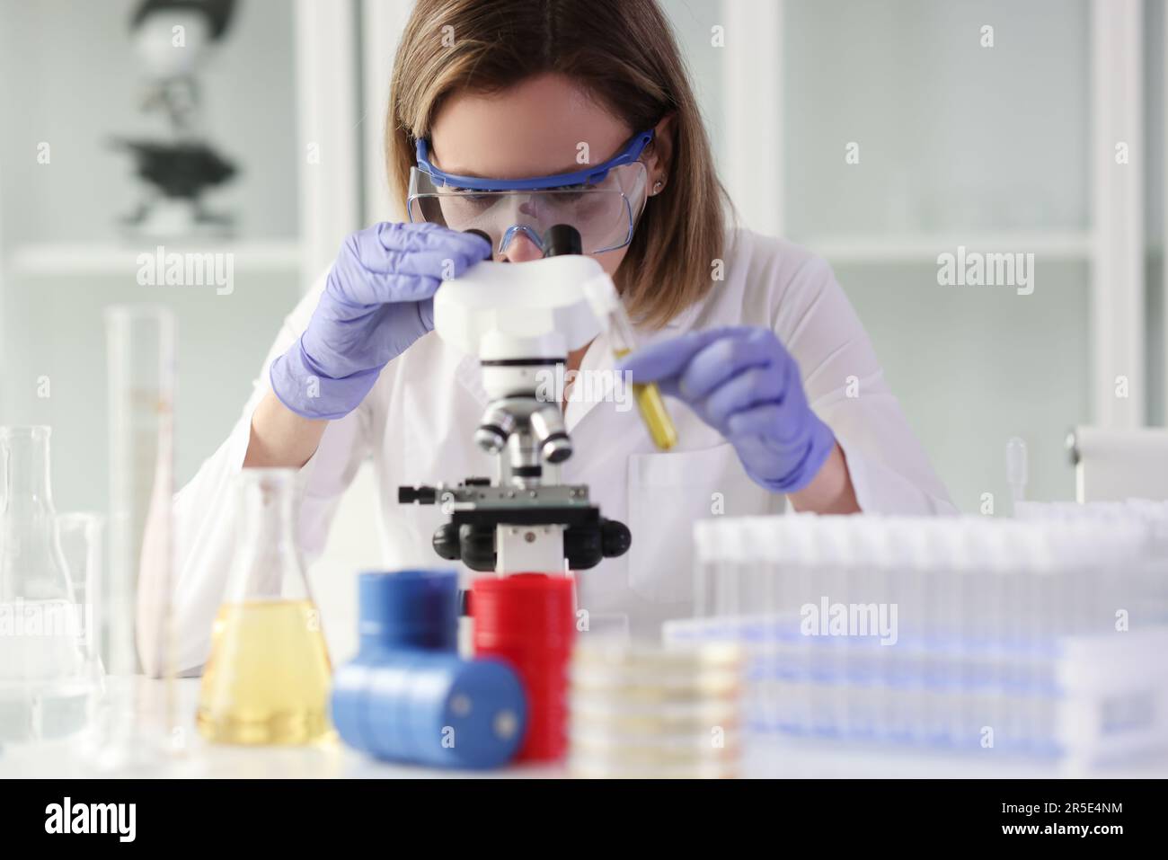 Laboratory worker examines substances under microscope Stock Photo - Alamy