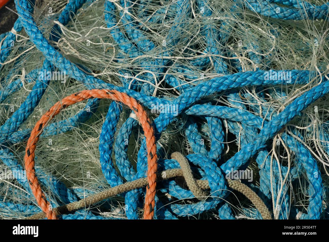 A pile of fishing rope and nylon netting. Close up view filling the ...
