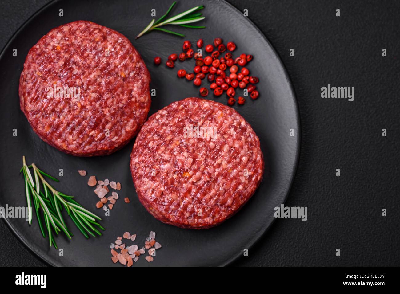 Fresh raw ground beef burger patty with salt and spices on textured ...