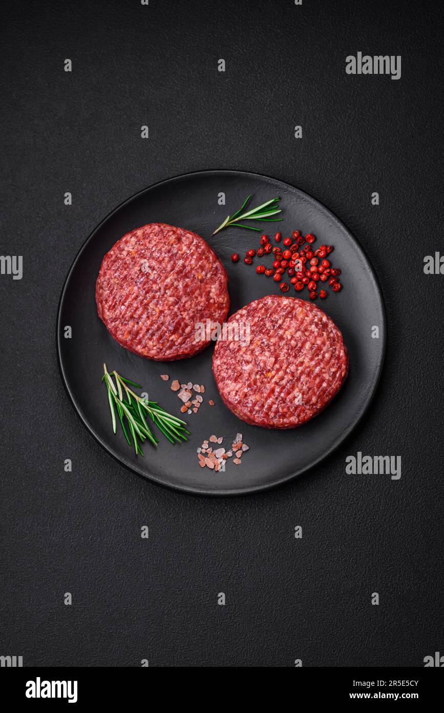 Fresh raw ground beef burger patty with salt and spices on textured ...