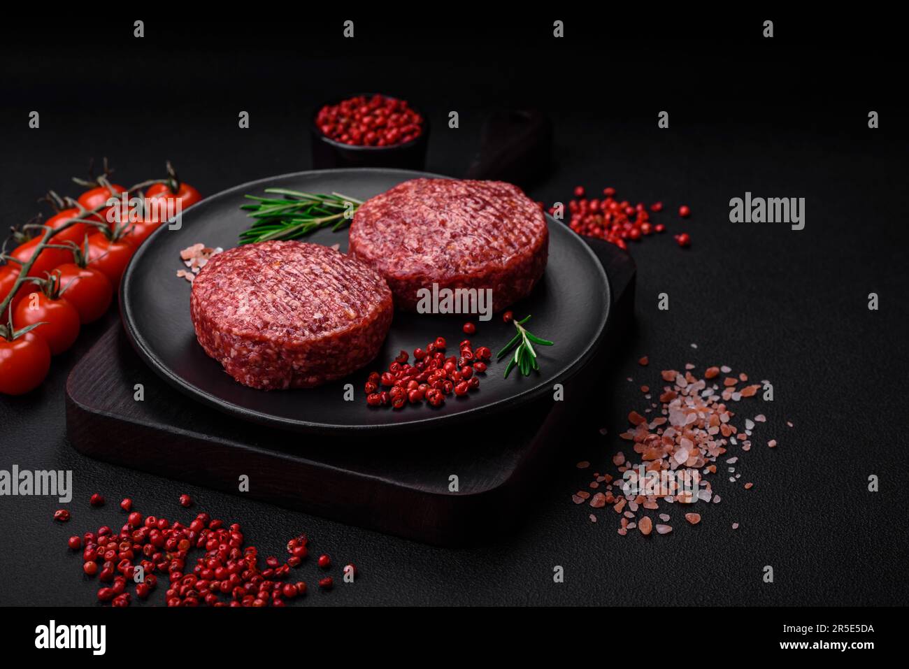 Fresh raw ground beef burger patty with salt and spices on textured ...