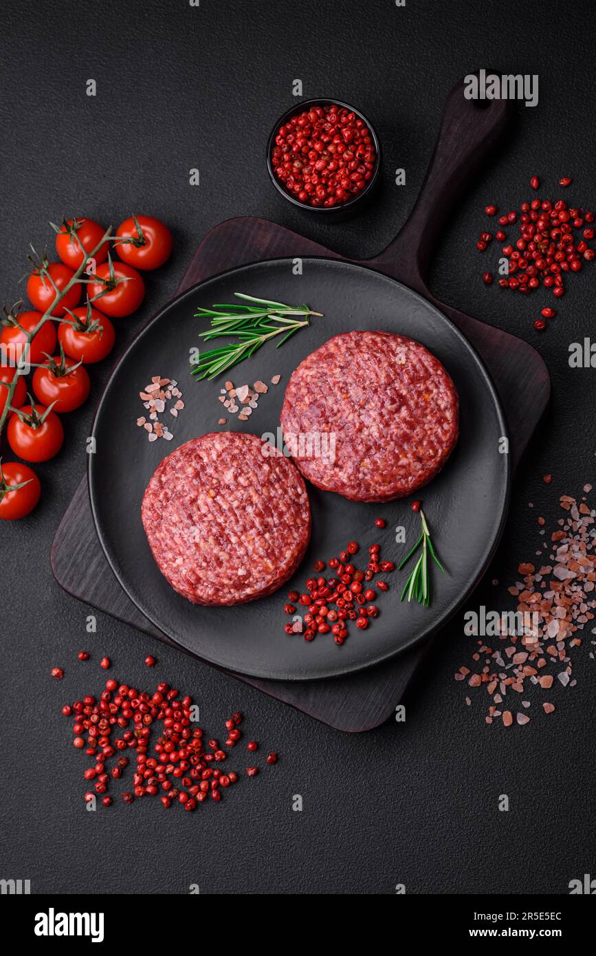 Fresh raw ground beef burger patty with salt and spices on textured ...