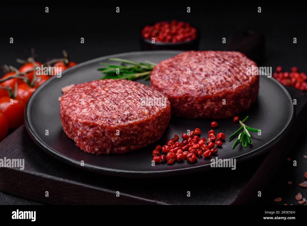Fresh raw ground beef burger patty with salt and spices on textured ...