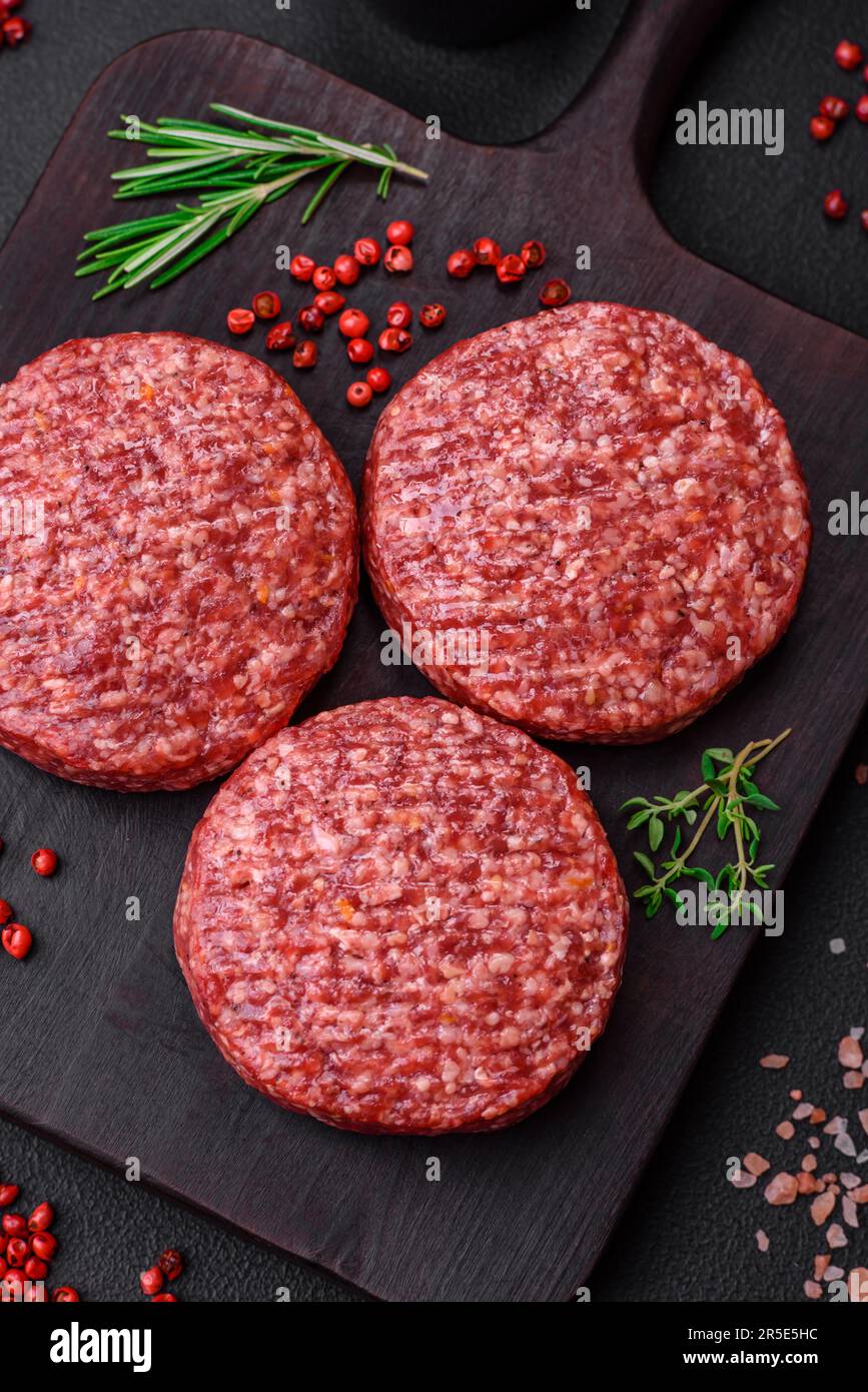Fresh raw ground beef burger patty with salt and spices on textured ...