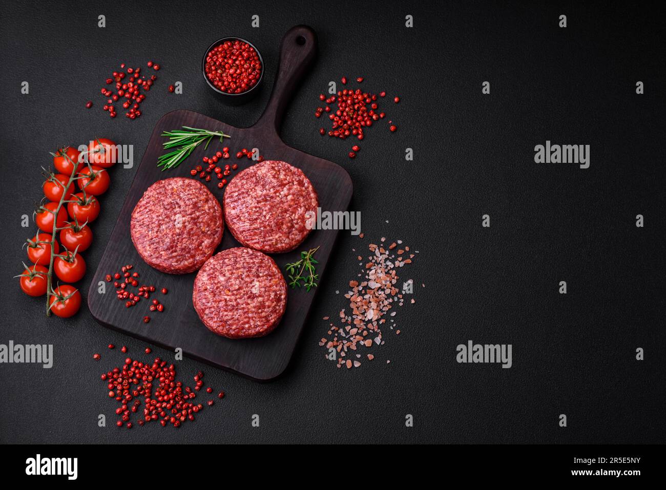 Fresh raw ground beef burger patty with salt and spices on textured ...