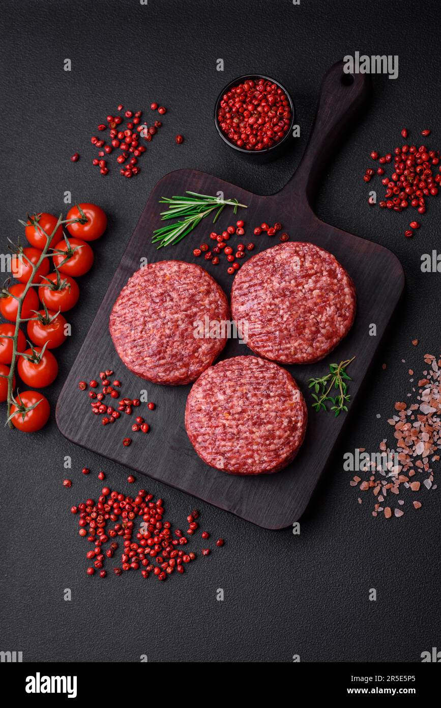 Fresh raw ground beef burger patty with salt and spices on textured ...