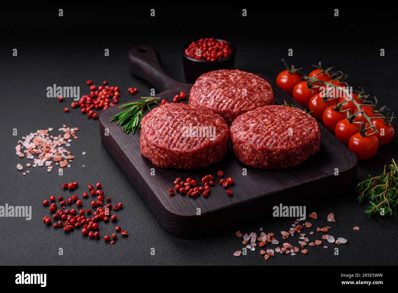 Fresh raw ground beef burger patty with salt and spices on textured ...