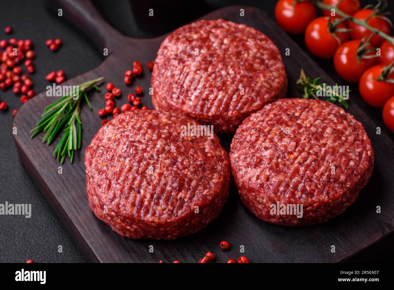 Fresh raw ground beef burger patty with salt and spices on textured ...