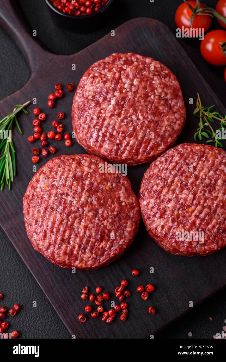 Fresh raw ground beef burger patty with salt and spices on textured ...