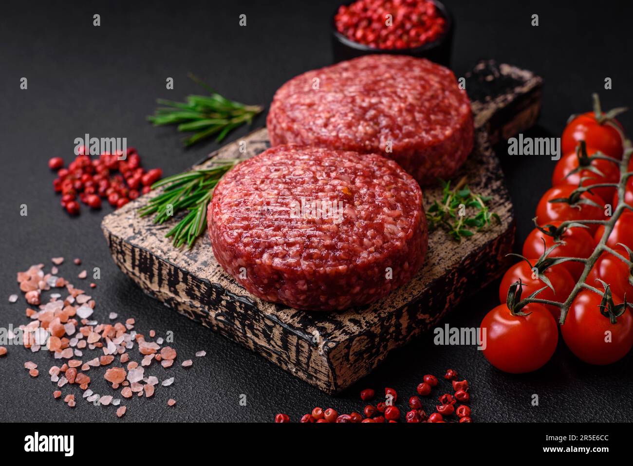 Fresh raw ground beef burger patty with salt and spices on textured ...