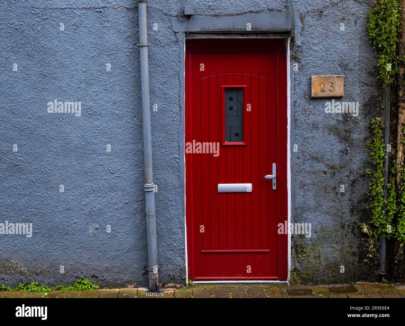Traditional English house facade front entrance with red closed door ...