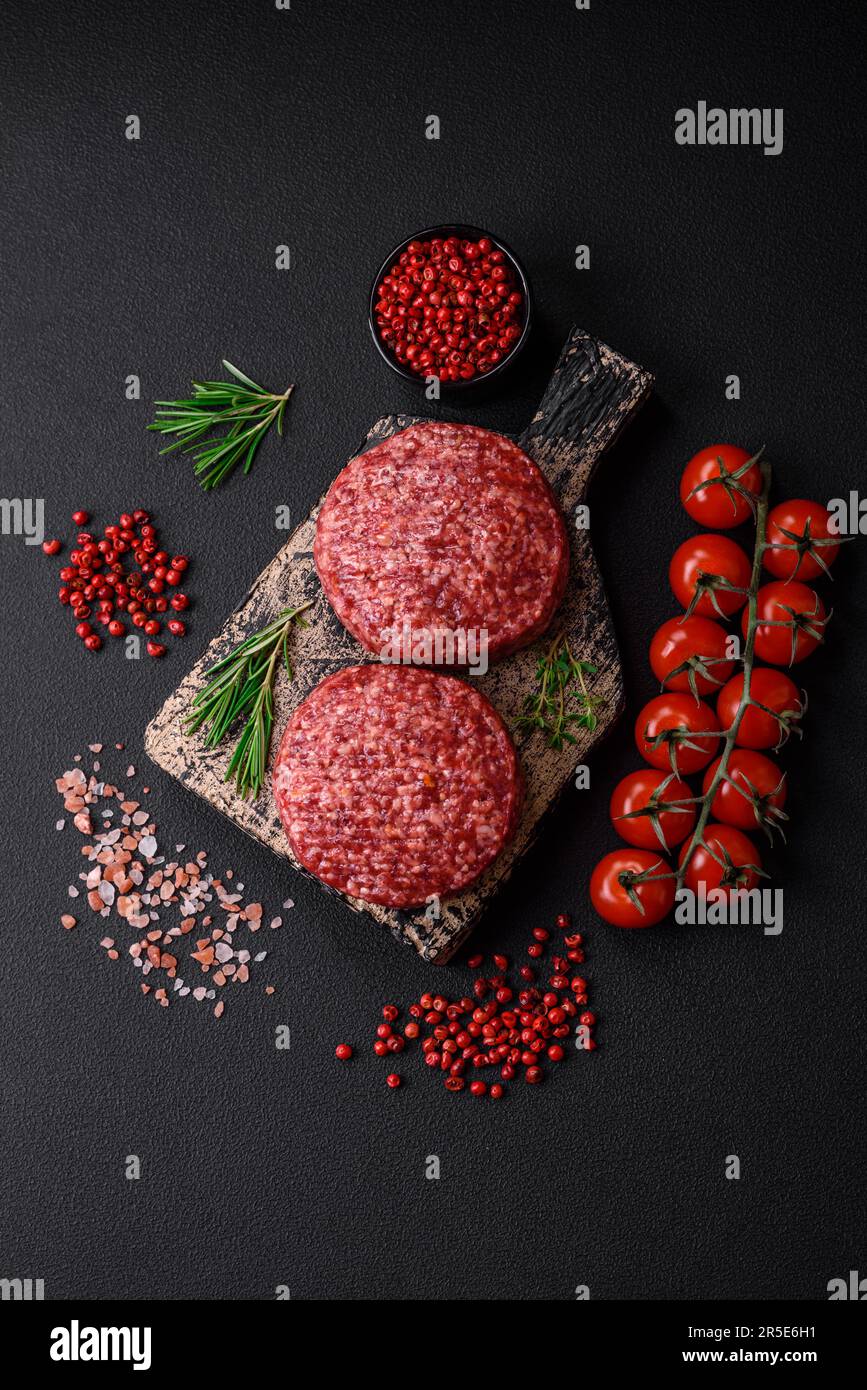 Fresh raw ground beef burger patty with salt and spices on textured ...