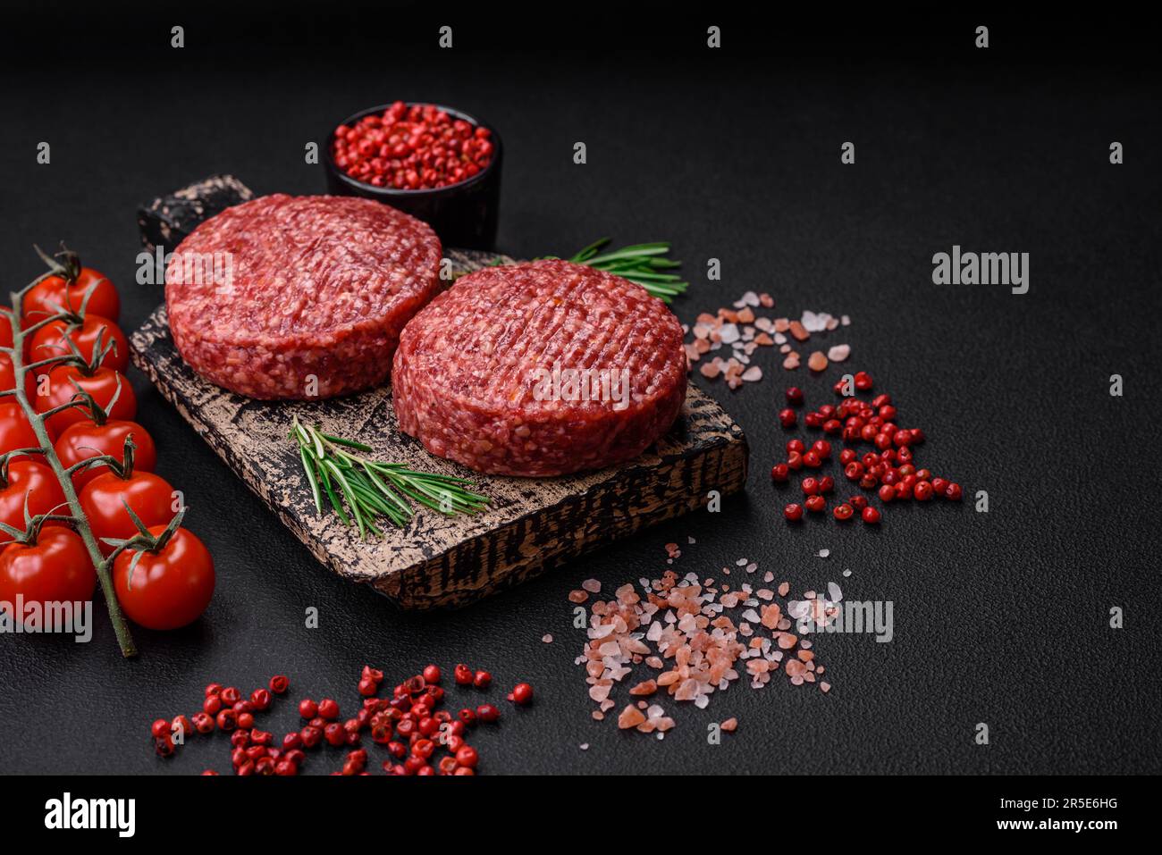 Fresh raw ground beef burger patty with salt and spices on textured ...