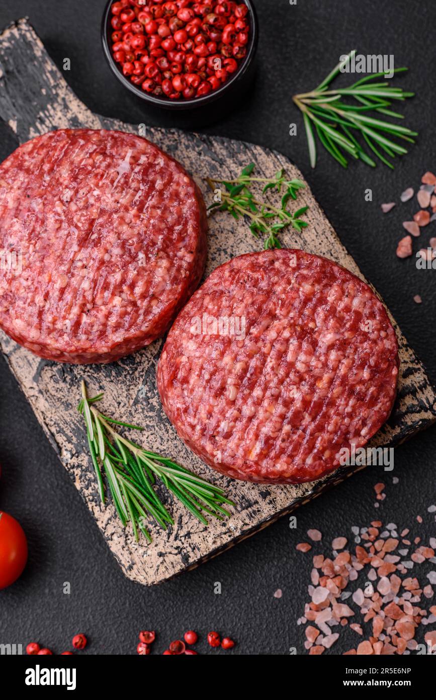 Fresh raw ground beef burger patty with salt and spices on textured ...