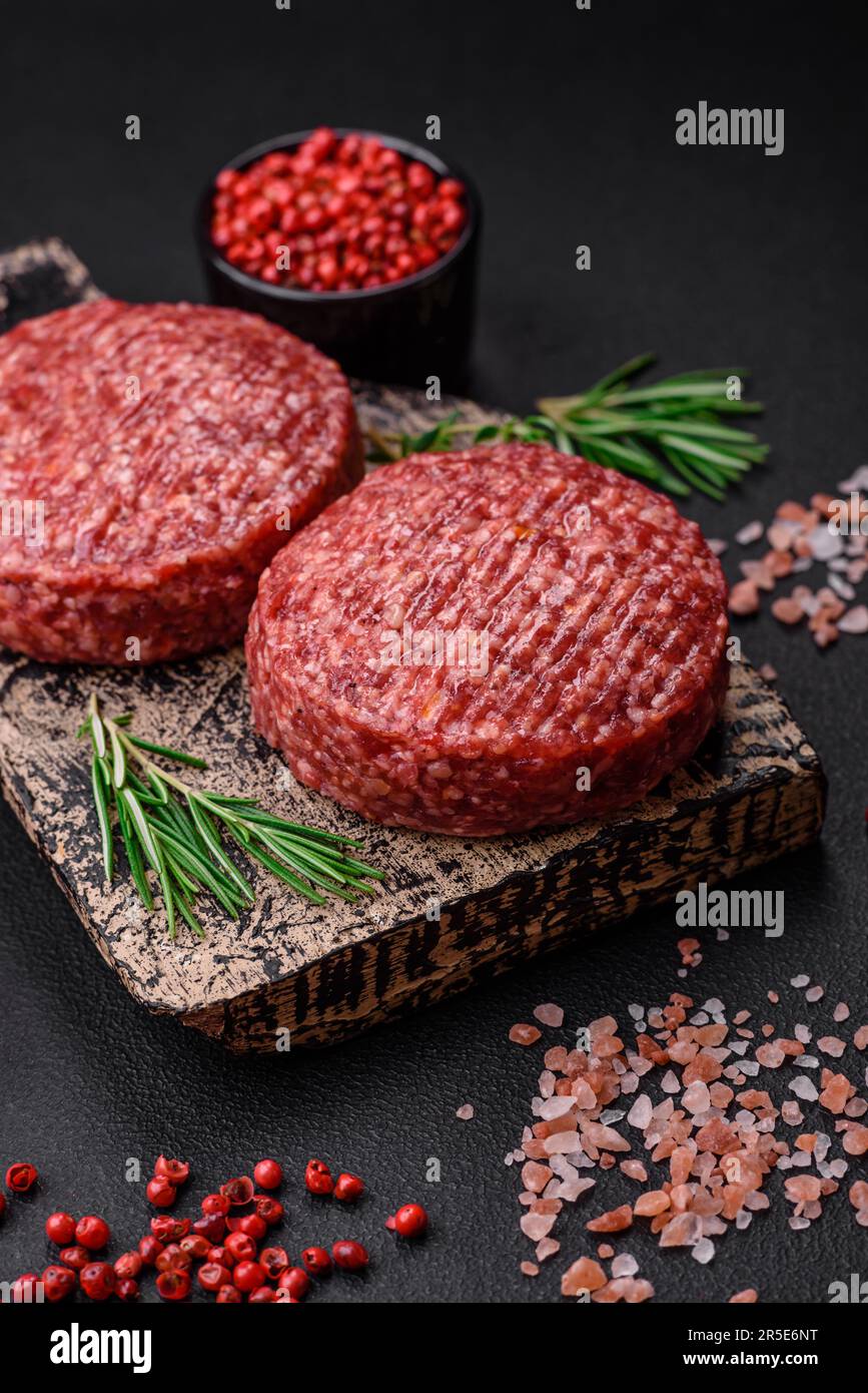 Fresh raw ground beef burger patty with salt and spices on textured ...