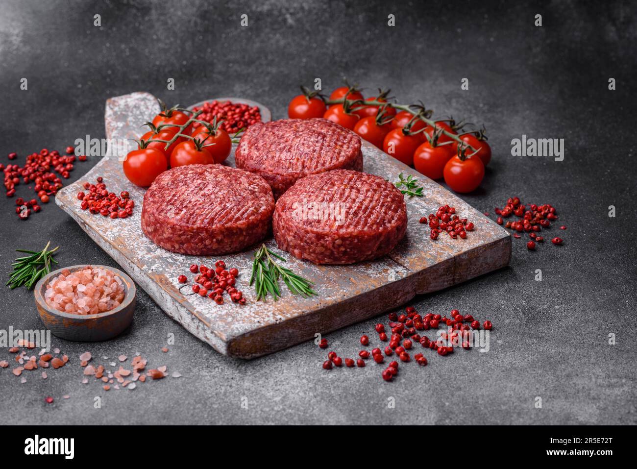 Fresh raw ground beef burger patty with salt and spices on textured ...