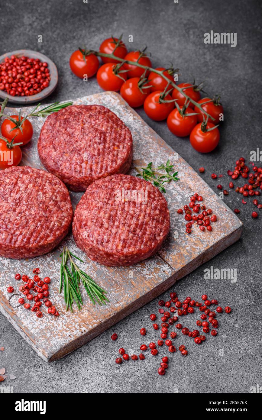 Fresh raw ground beef burger patty with salt and spices on textured ...