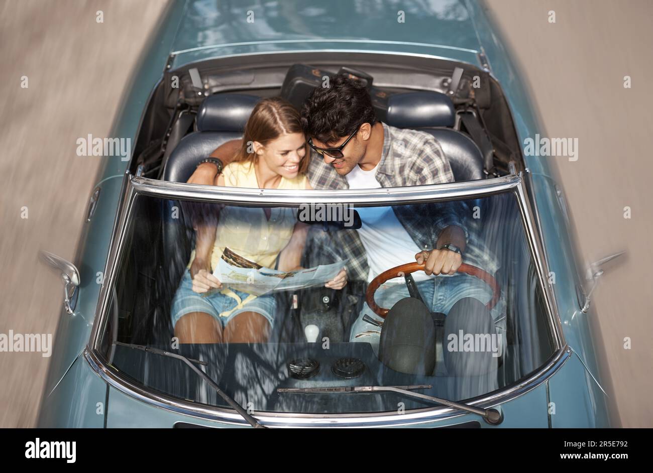 Our fun day in the sports car. Cropped image of a young couple sitting ...