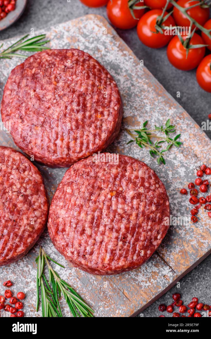 Fresh raw ground beef burger patty with salt and spices on textured ...