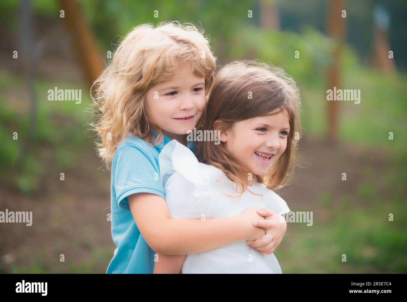 Little brother and sister, boy and girl playing on park outdoors. Happy ...