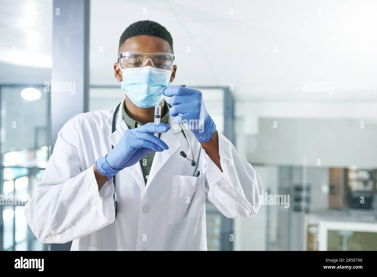 The needles not that bad. a young doctor holding a syringe in an office ...