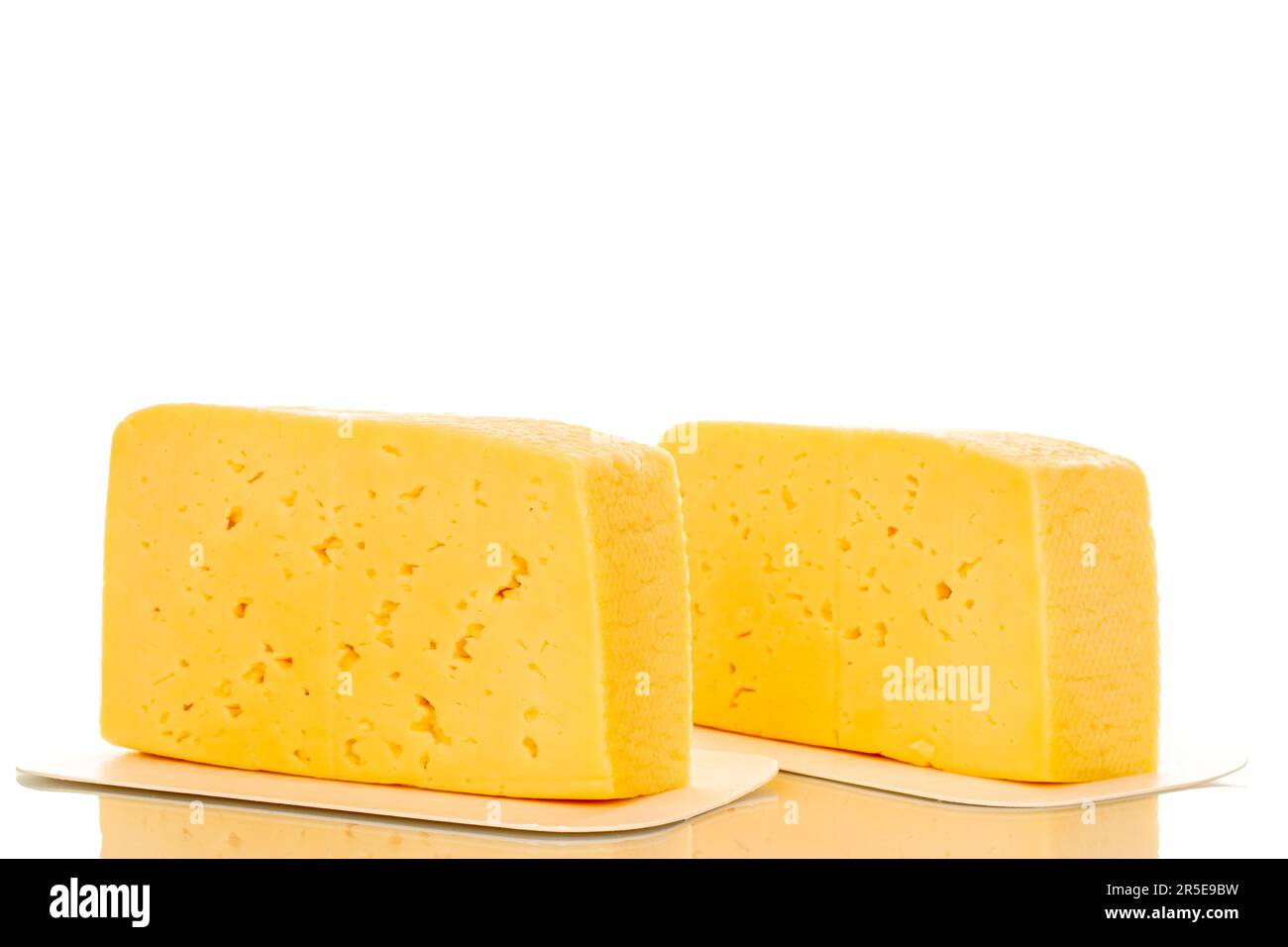 Two pieces of cheese on a white paper plate, macro, isolated on a white ...