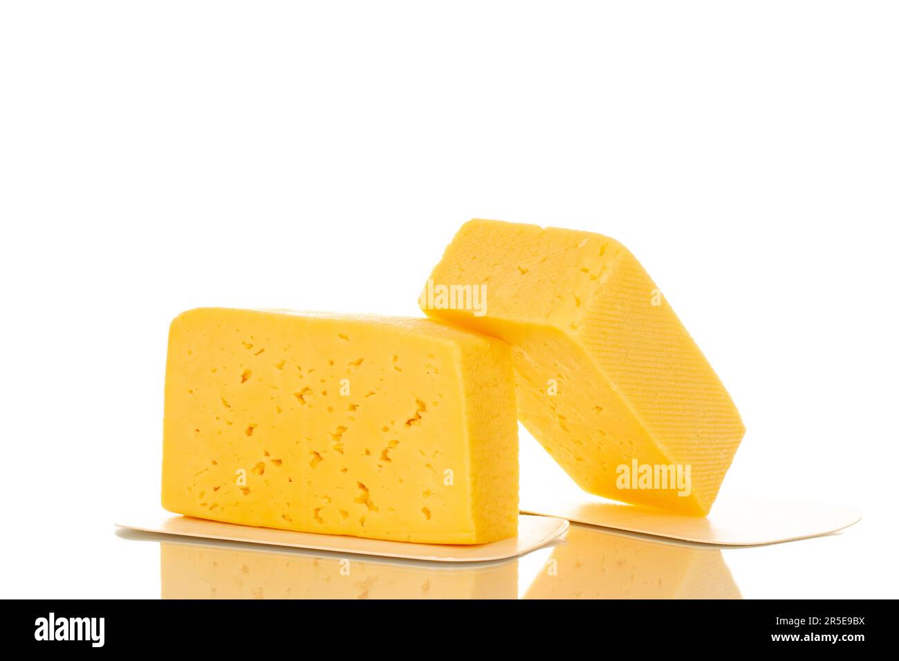 Two pieces of cheese on a white paper plate, macro, isolated on a white ...