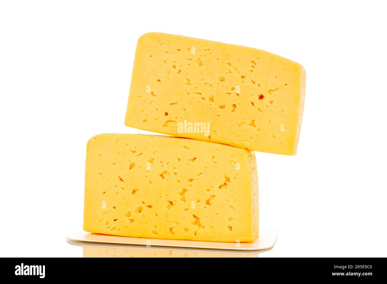Two pieces of cheese on a white paper plate, macro, isolated on a white ...