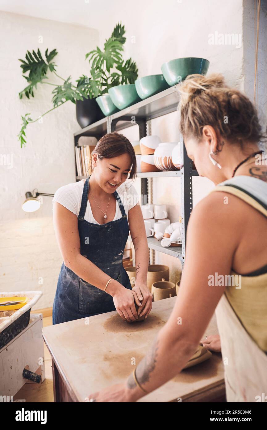 You cant be sad with clay in your hands. two young women kneading clay ...
