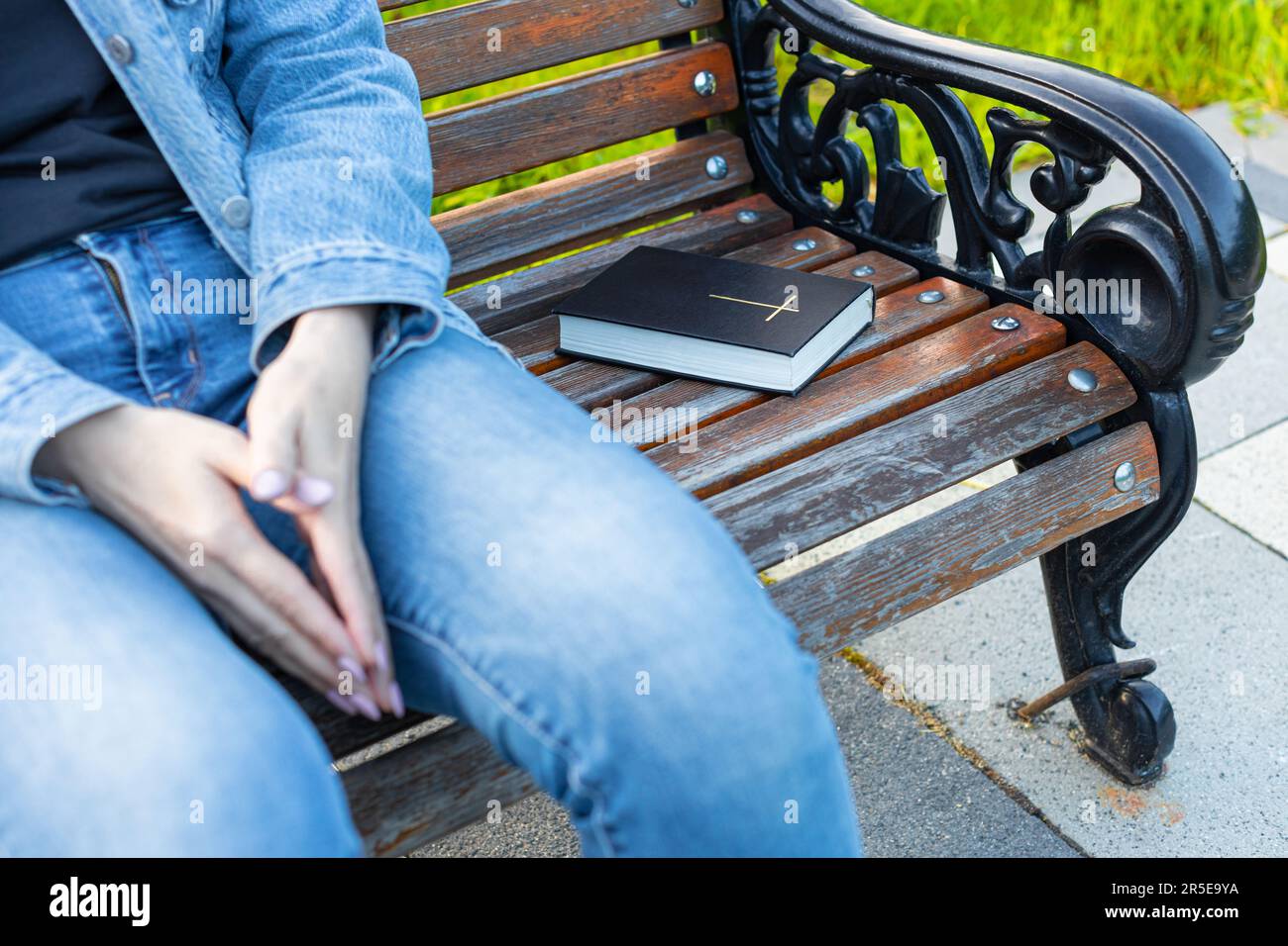 the bible lies on the bench next to the woman. woman asks god for help ...