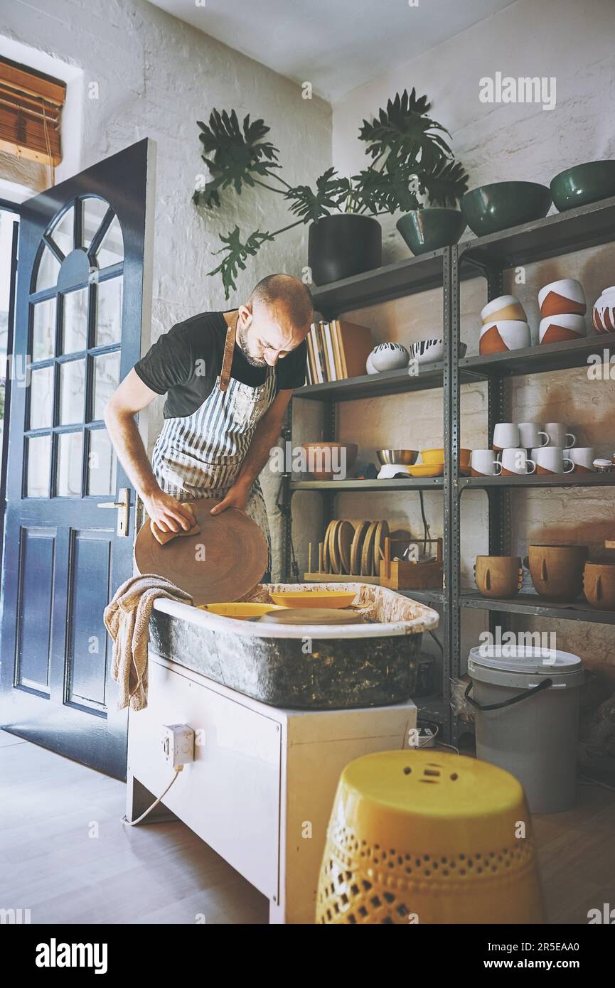Cleaning as you go is the way to go. a young man cleaning a pottery ...